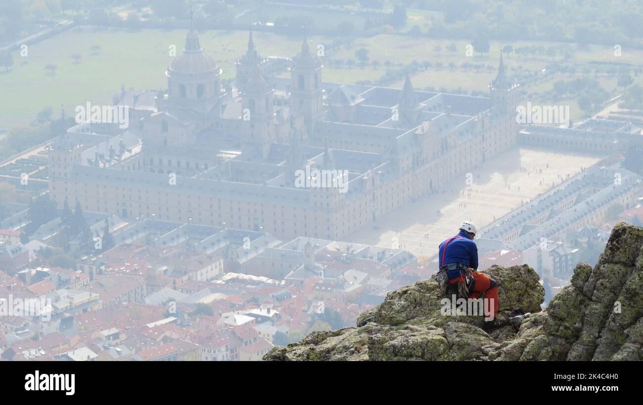 A climber in safety attire climbing mount Abantos against a display of ...