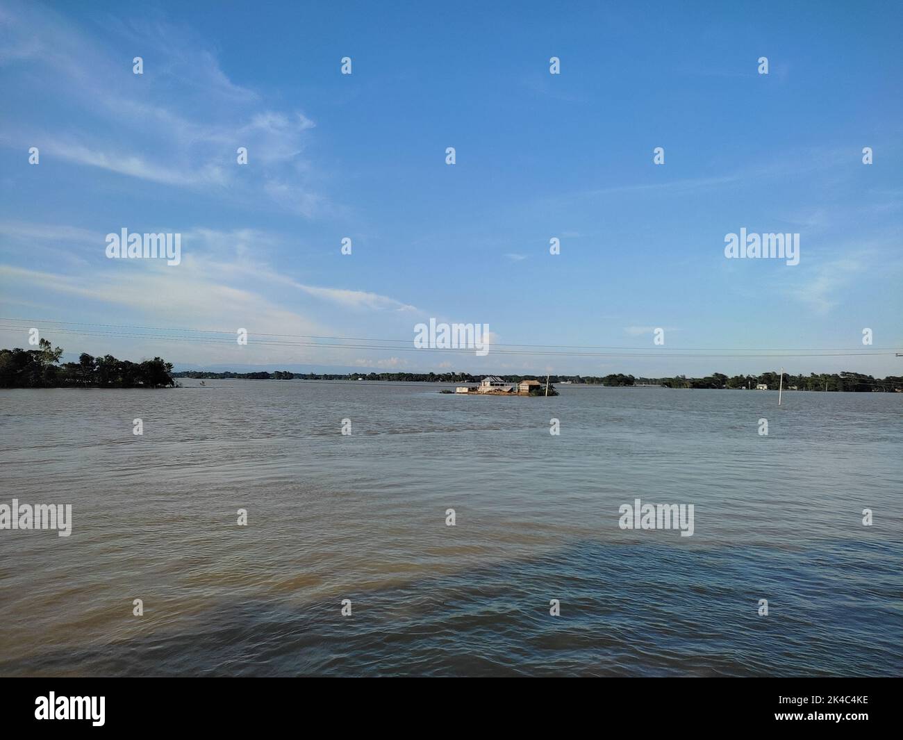 An aerial view lake with floating boat surrounded by trees under blue ...