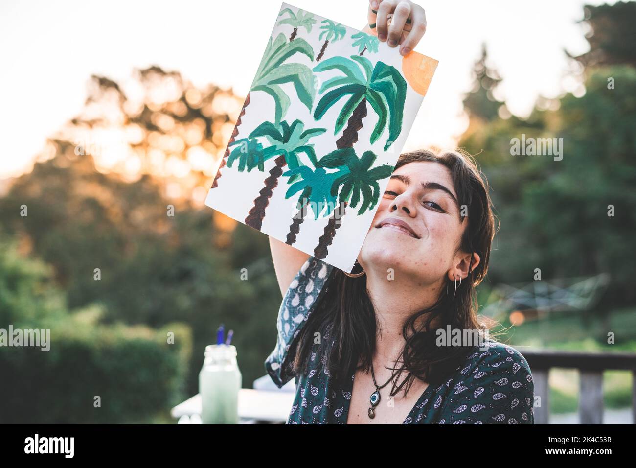 Young girl smiling and showing her work when she finished painting it ...