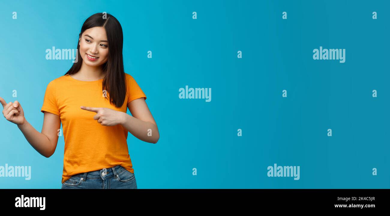 Tender lovely asian girl with dark haircut look curiously pointing left ...