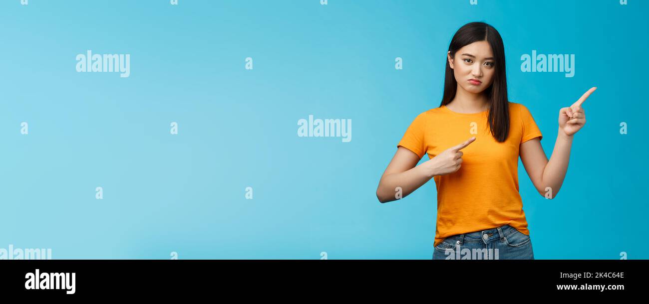 Picky disappointed asian girl with unsatisfied face, pointing upper ...