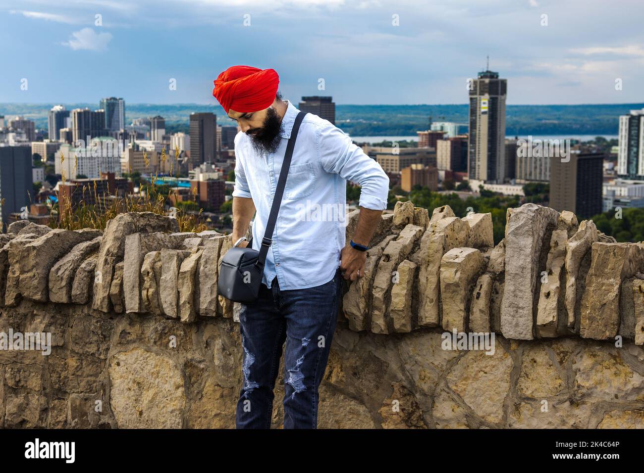 An Asian man leaning backwards on the brick fence Stock Photo - Alamy
