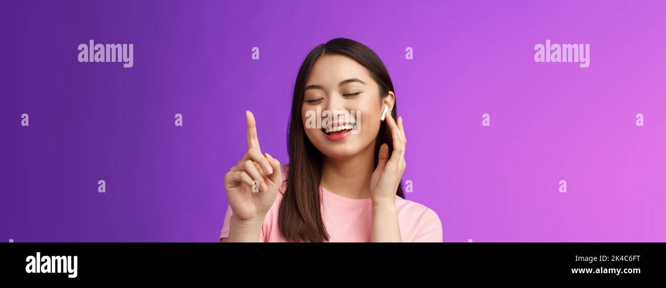 Close-up cheerful glad attractive asian woman close eyes raising one ...