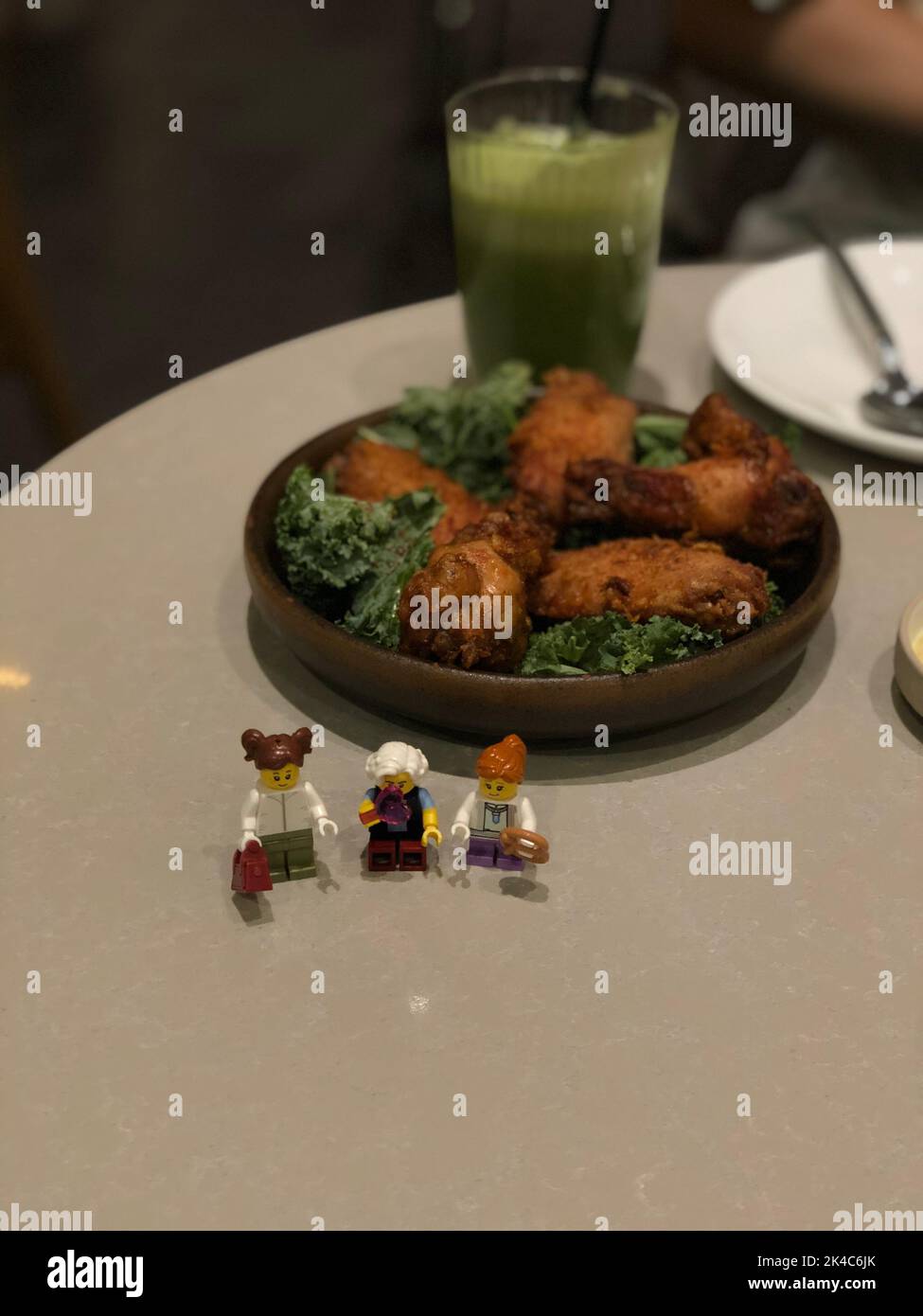 A chicken wings and lego men on a dining table Stock Photo - Alamy