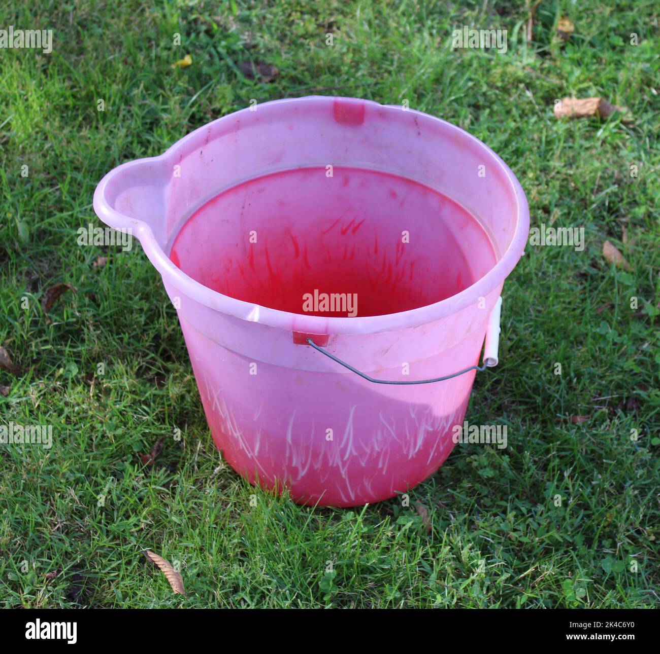 An Old Plastic Red Bucket Faded from the Sun Stock Photo - Alamy