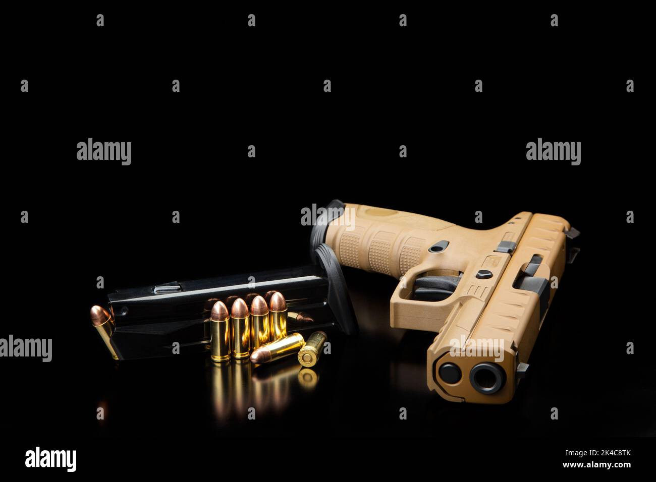 Brown modern gun and ammunition for it on adark background. Short ...