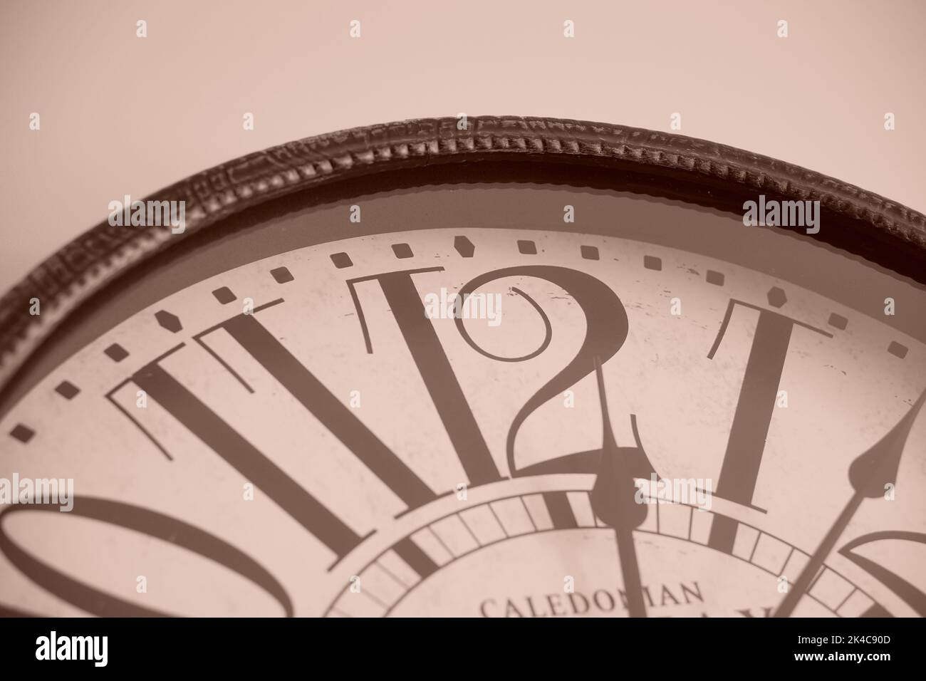 A closeup of a classic retro large clock with Roman symbols hanging on ...