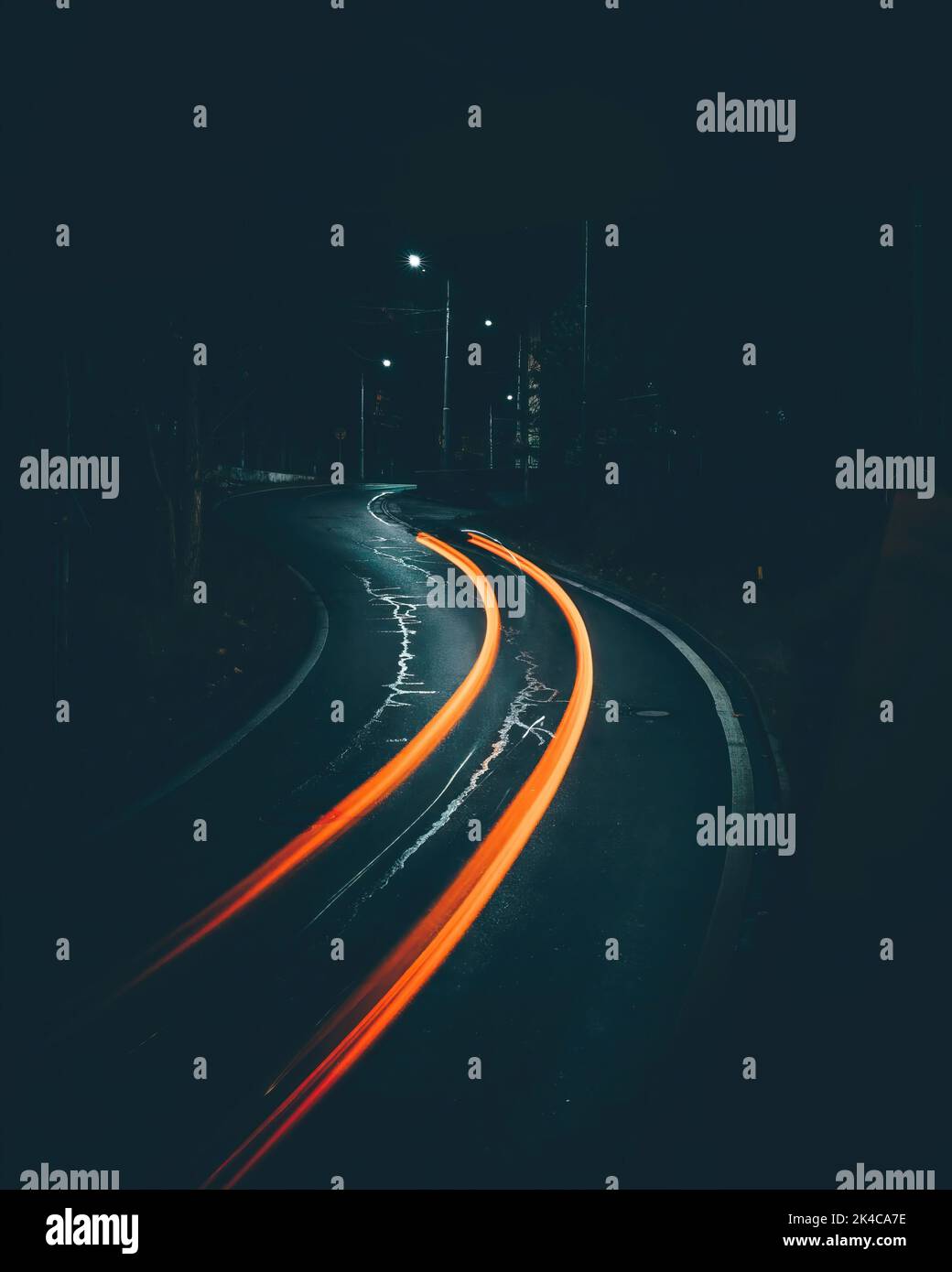 A vertical shot of orange light trails on a night road Stock Photo - Alamy