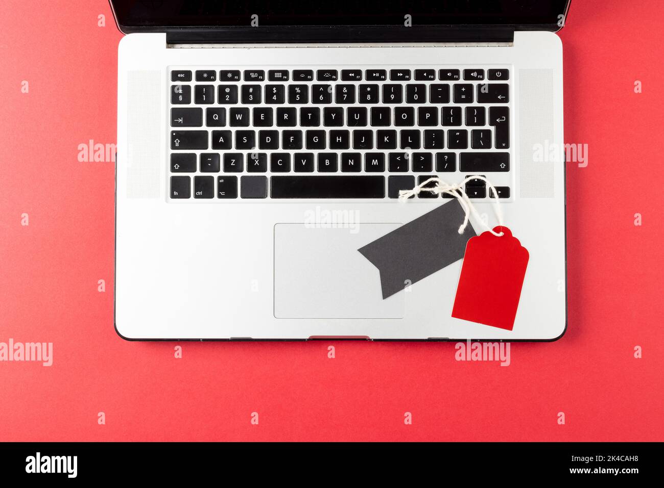 Composition of laptop and gift tags on pink background Stock Photo - Alamy