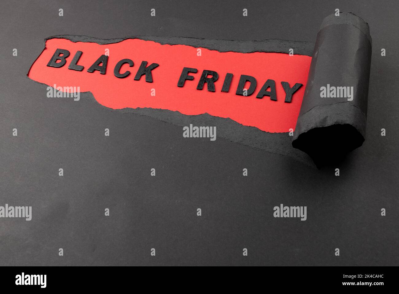 Composition of black paper and black friday text on red background ...
