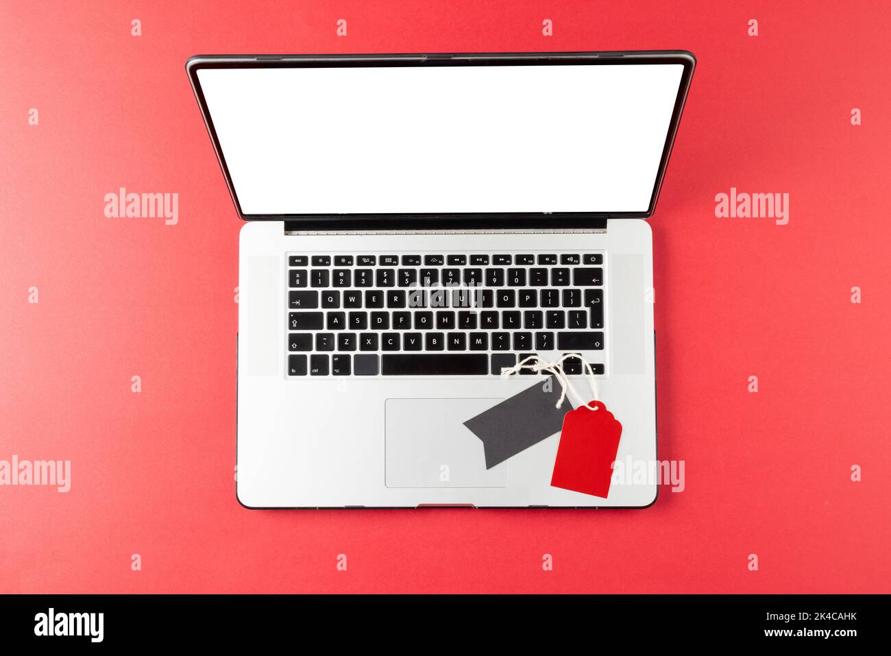 Composition of laptop and gift tags on pink background Stock Photo - Alamy