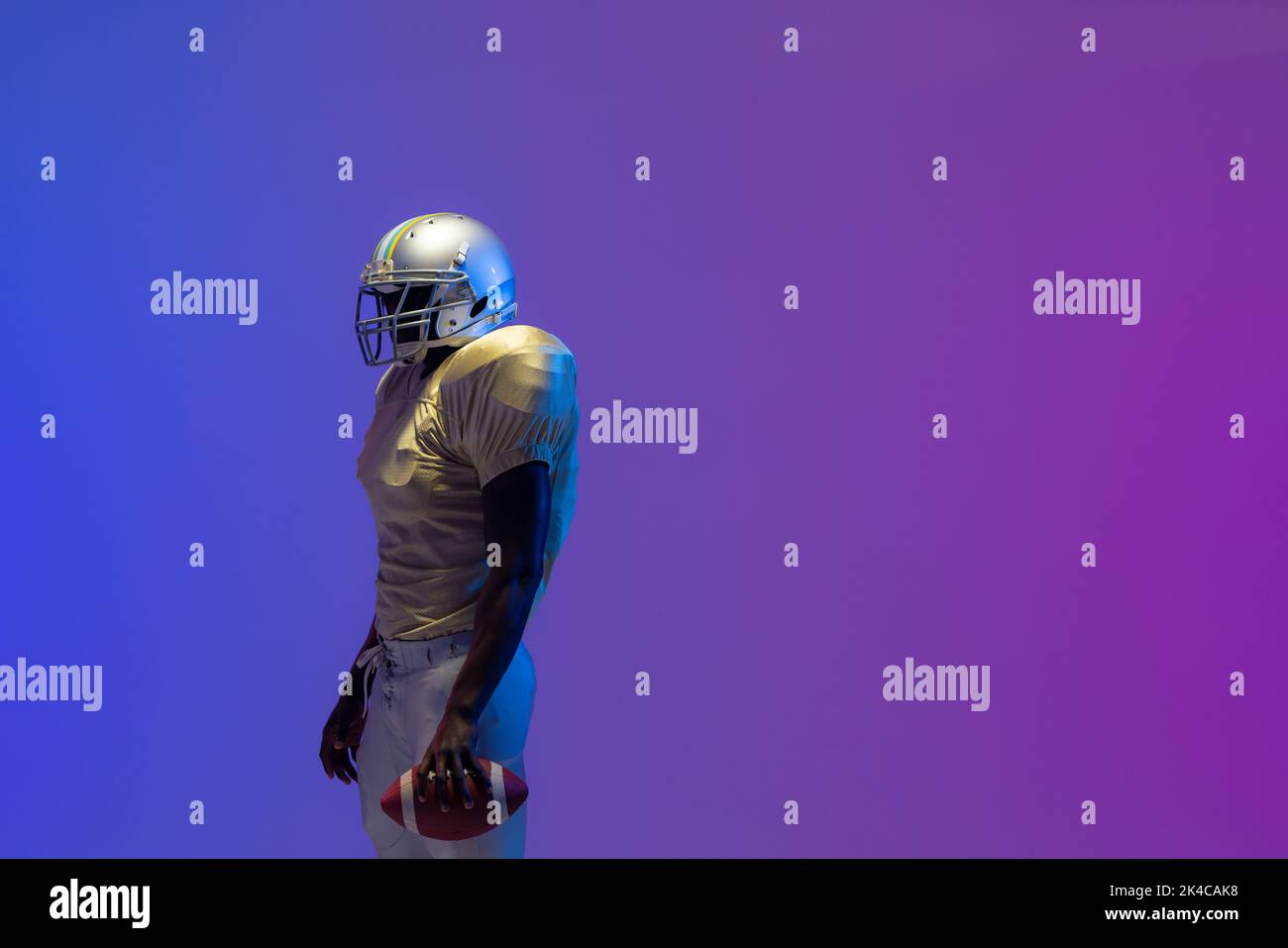 African american male american football player holding ball with neon ...