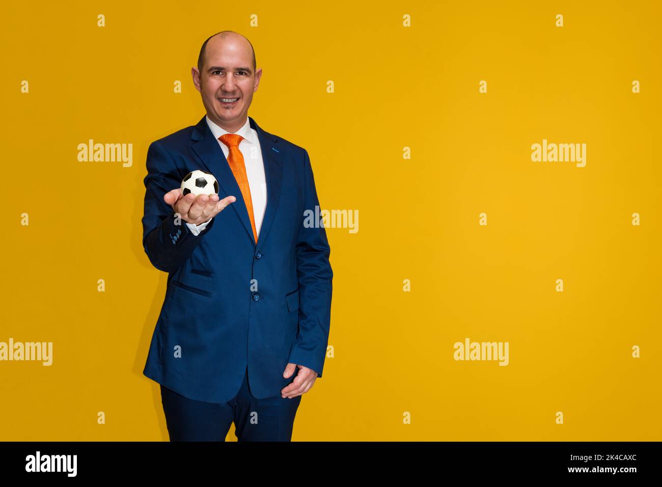 A bald Caucasian bald adult male wearing a blue suit, white shirt and ...