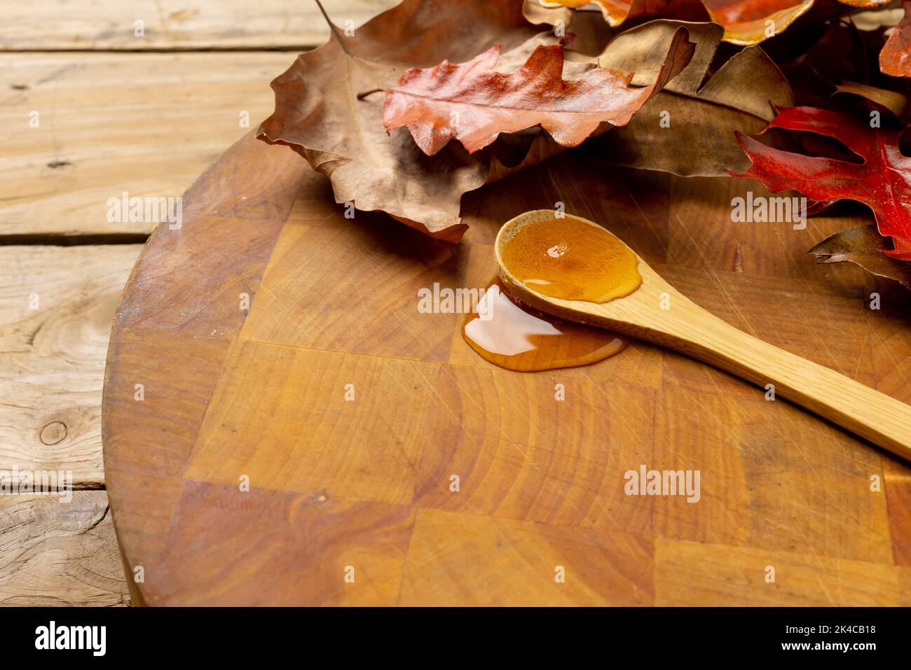 Horizontal image of autumn leaves and wooden spoon of maple syrup on ...