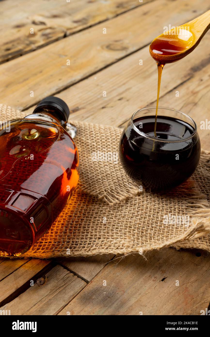 Horizontal image of bottle, wooden spoon and bowl of maple syrup on ...