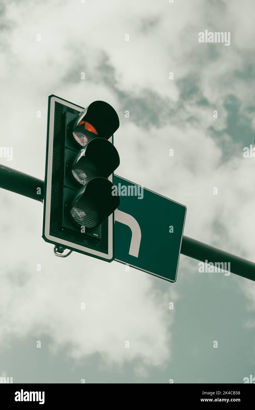 A low angle view of traffic lights showing red and a board with ...