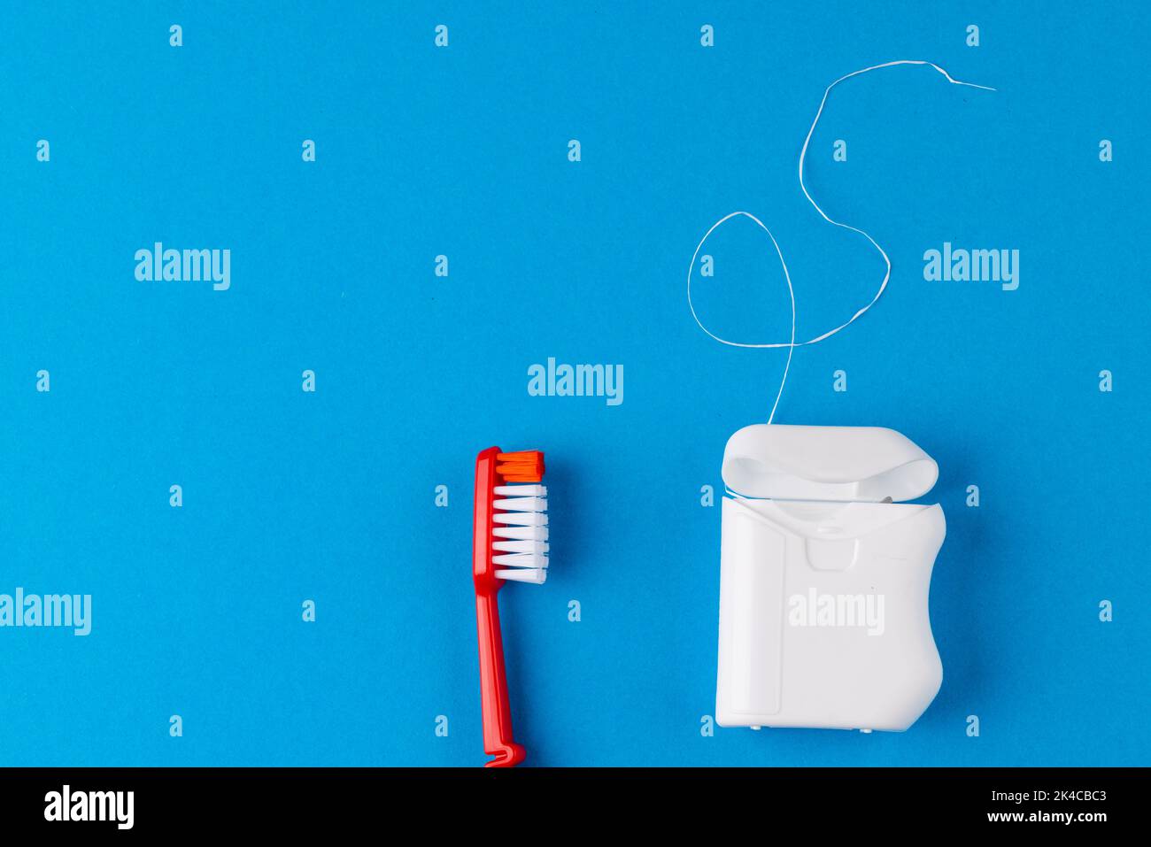 Image of toothbrush and dental string on blue surface Stock Photo - Alamy