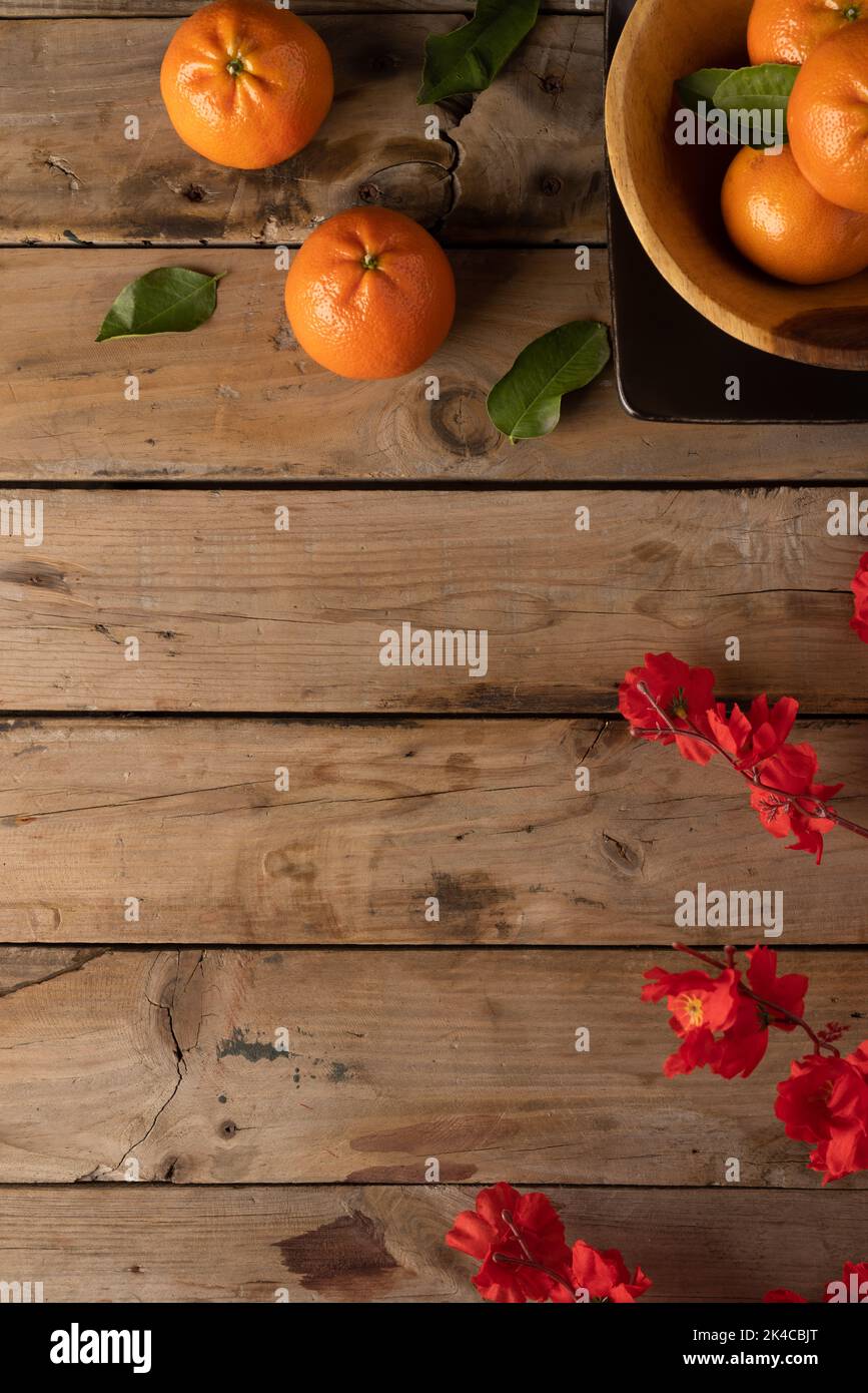 Composition of red flowers and oranges on wooden background Stock Photo ...