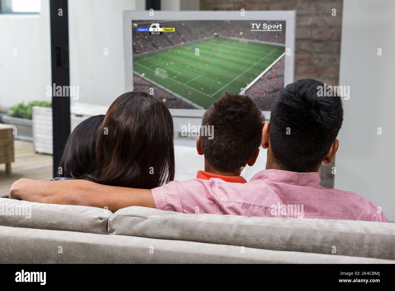Caucasian family watching tv with football match on screen Stock Photo ...