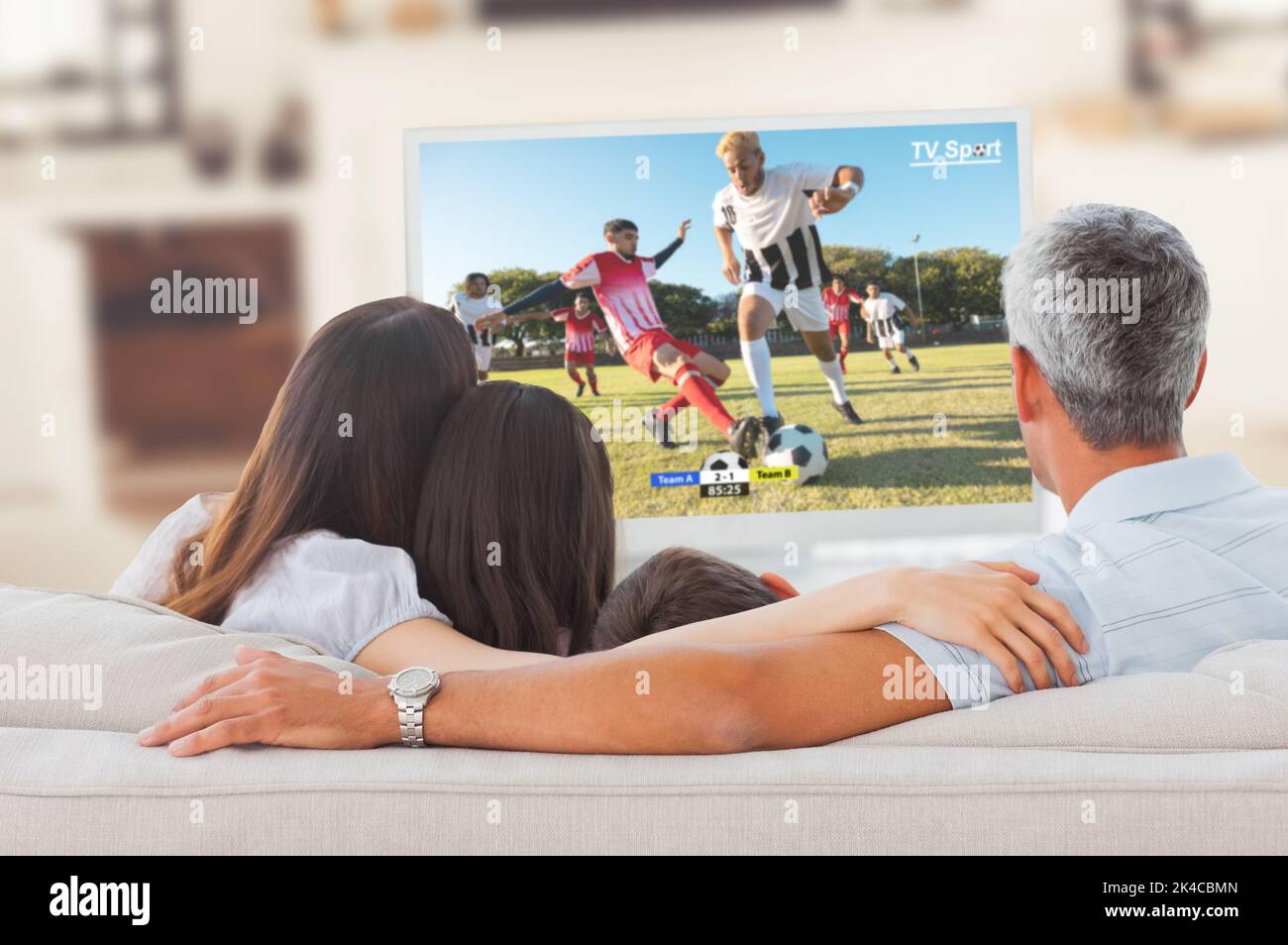 Caucasian family watching tv with football match on screen Stock Photo ...