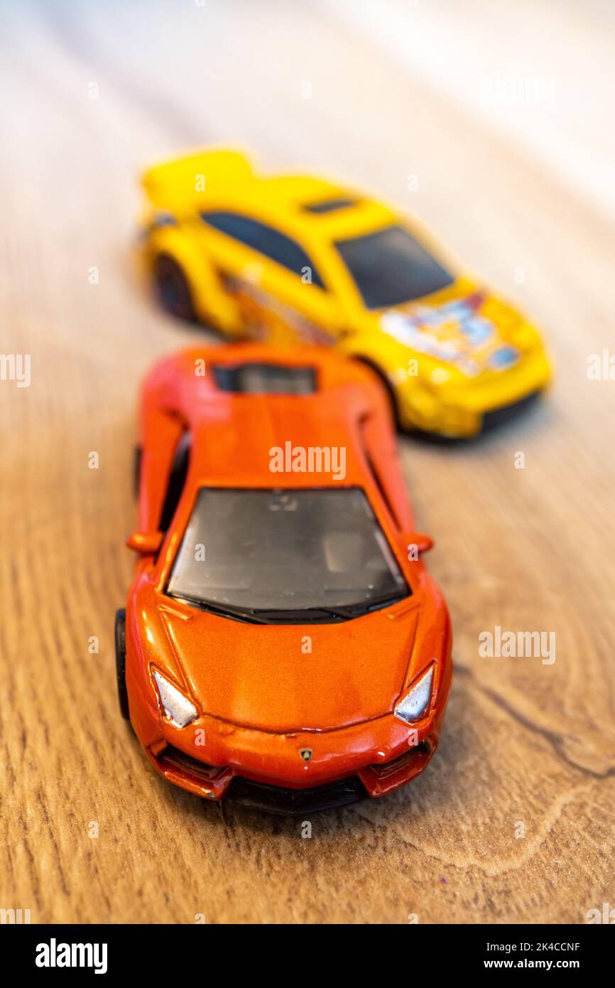 A vertical closeup of Mattel Hot Wheels toy model cars on wooden ...