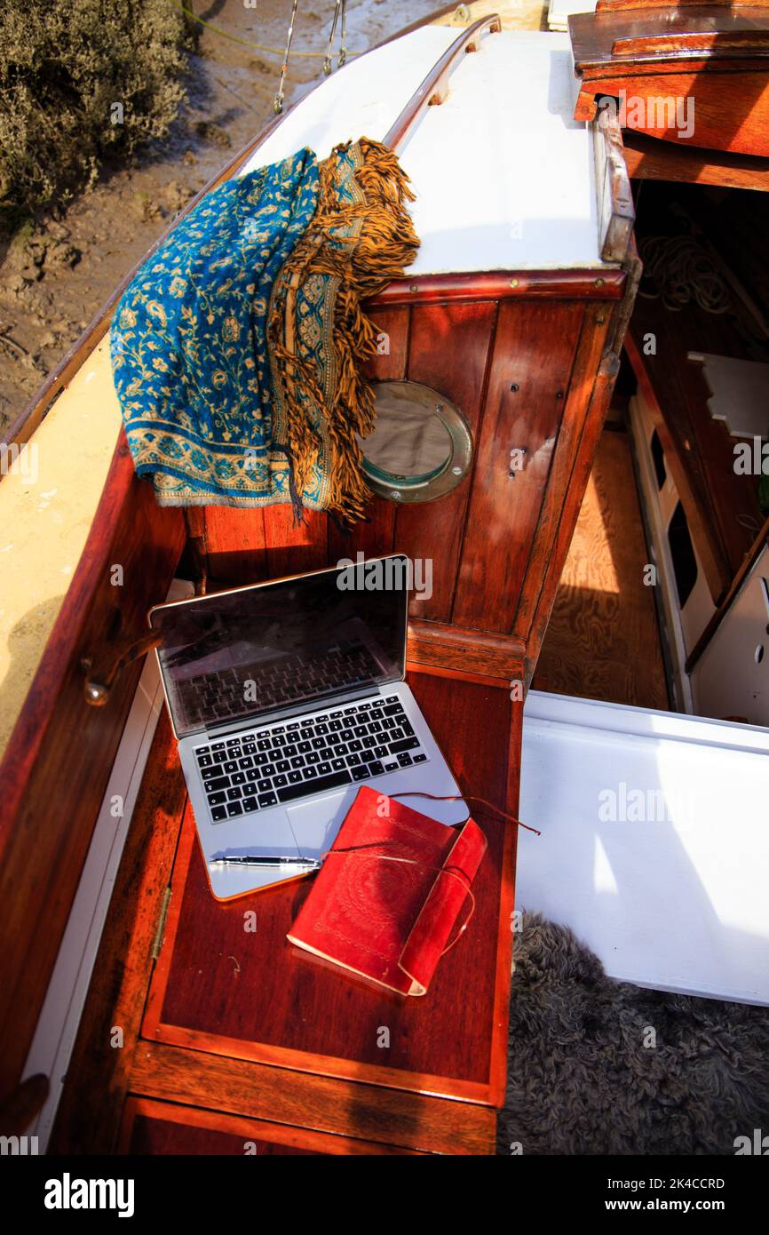 A vertical closeup shot of a leather notebook and opened laptop ...