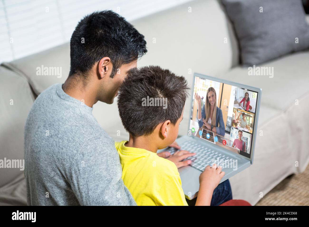 Father and son using laptop on the sofa in living room Stock Photo - Alamy