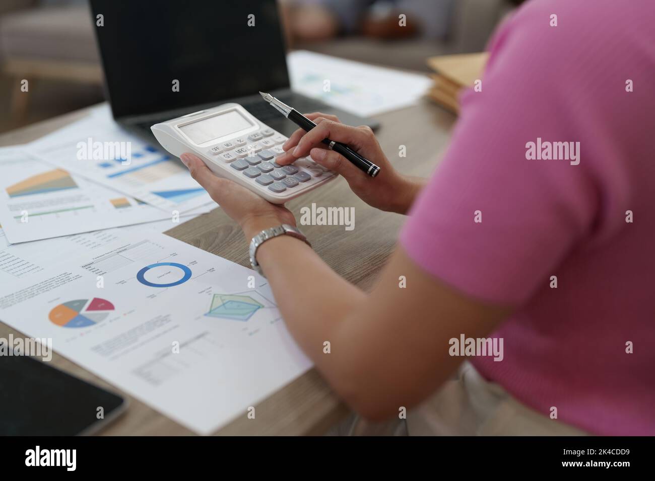 Business woman hand using calculator to calculate the company's ...