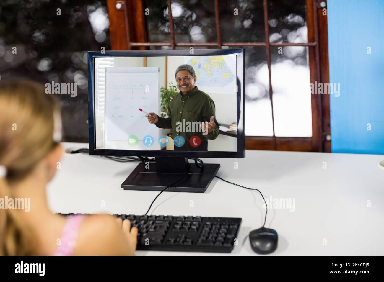 Female student having a video call with male teacher on computer at ...