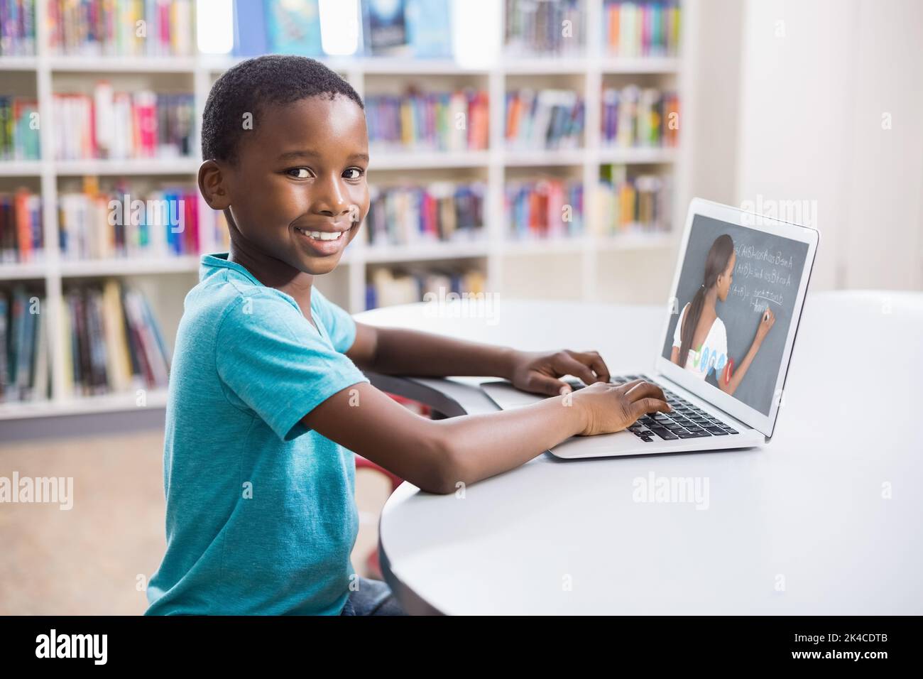 Portrait of smiling african american schoolboy using laptop on video ...