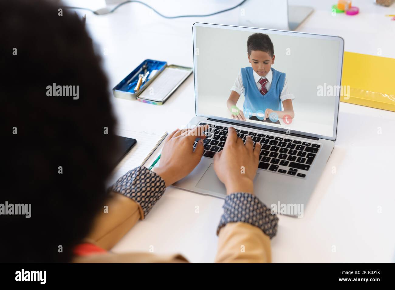Female teacher having a video call with male student on laptop at ...