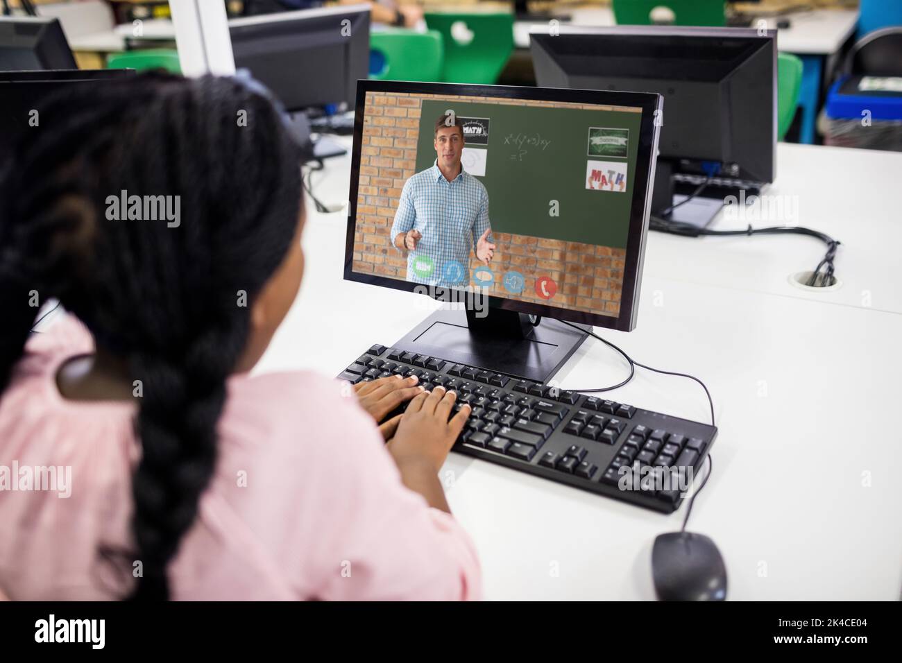 Female student having a video call with male teacher on computer at ...