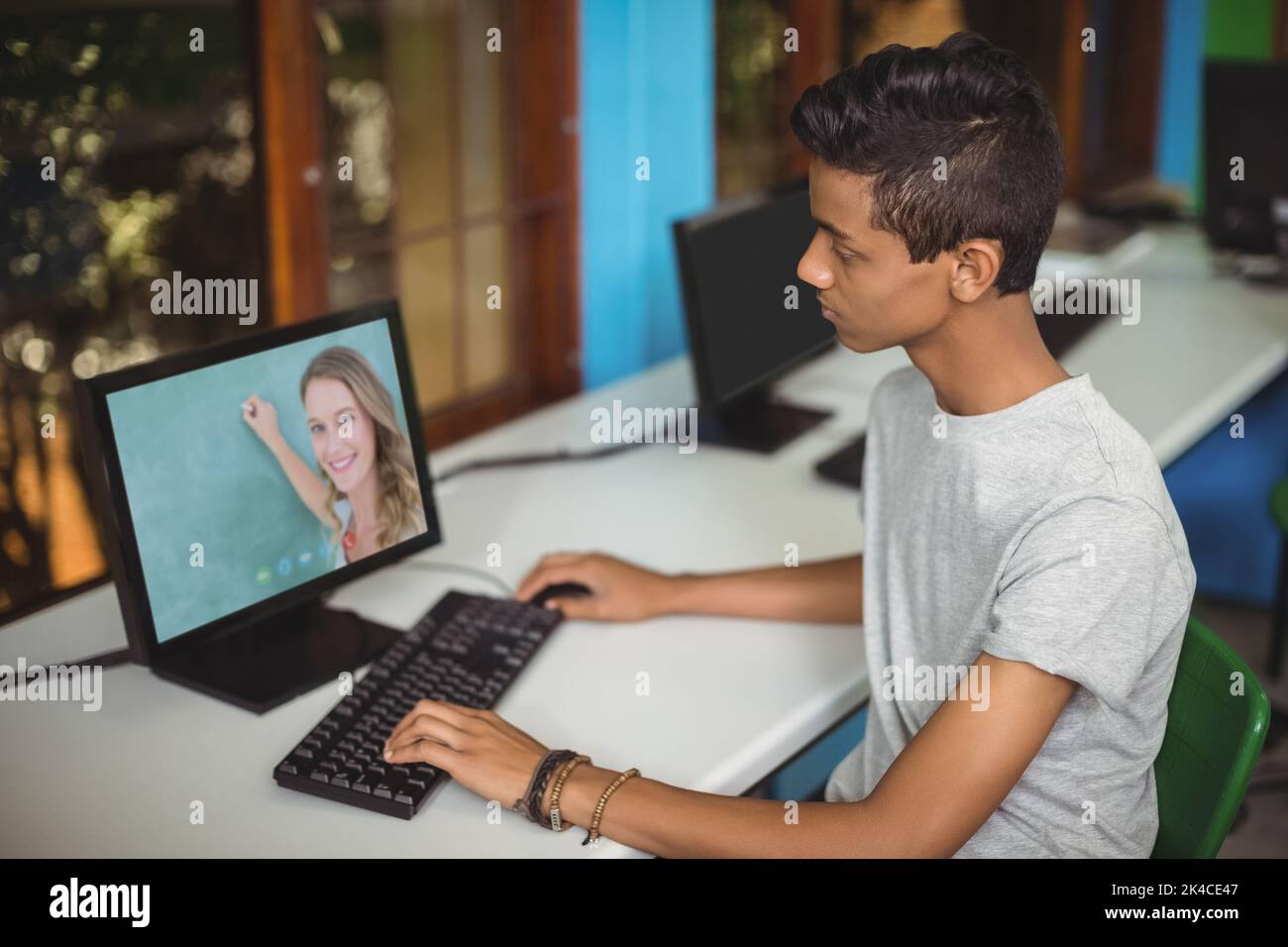 Male indian student having a video call with female teacher on computer ...