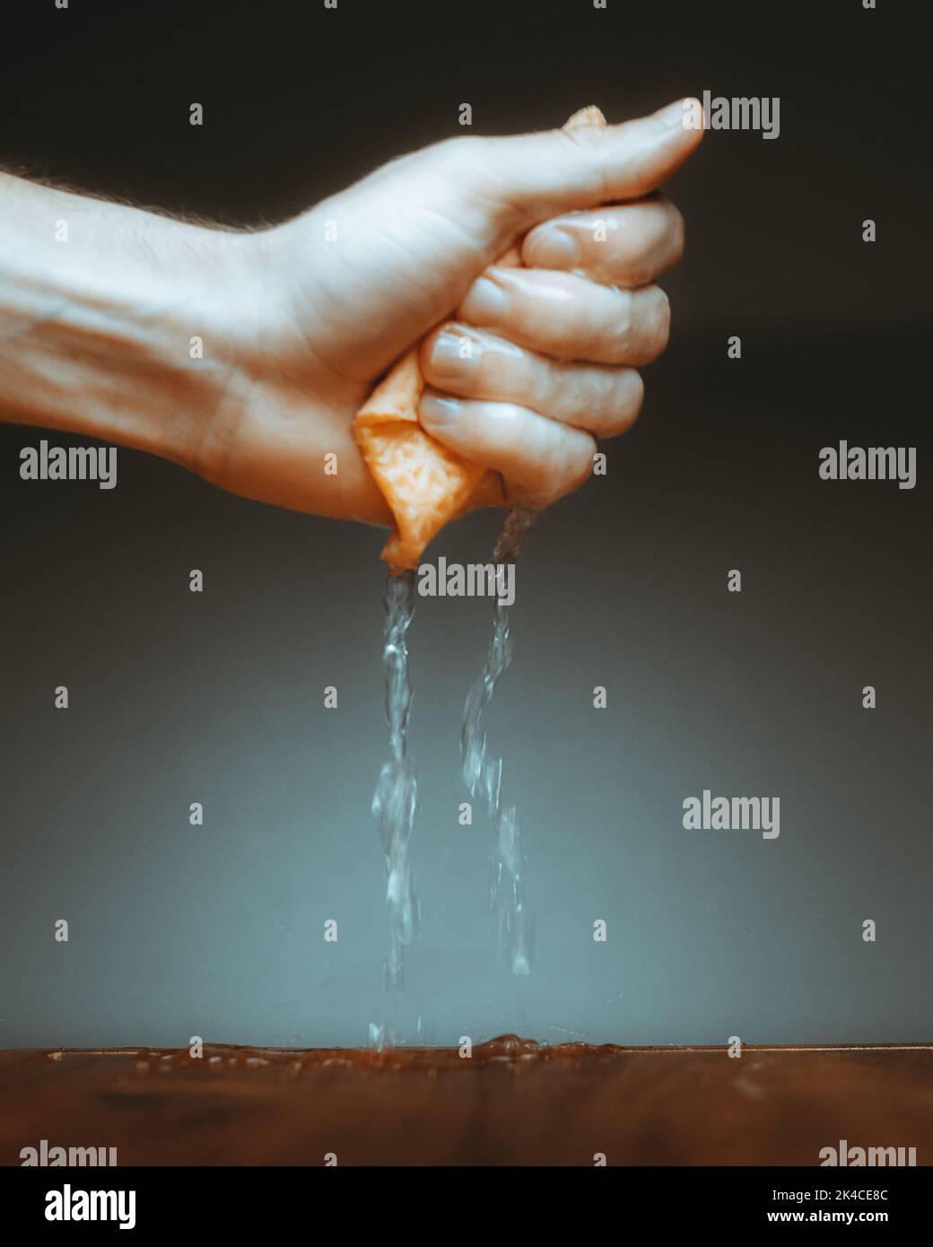 A vertical closeup of a hand squeezing a sponge wipe Stock Photo - Alamy