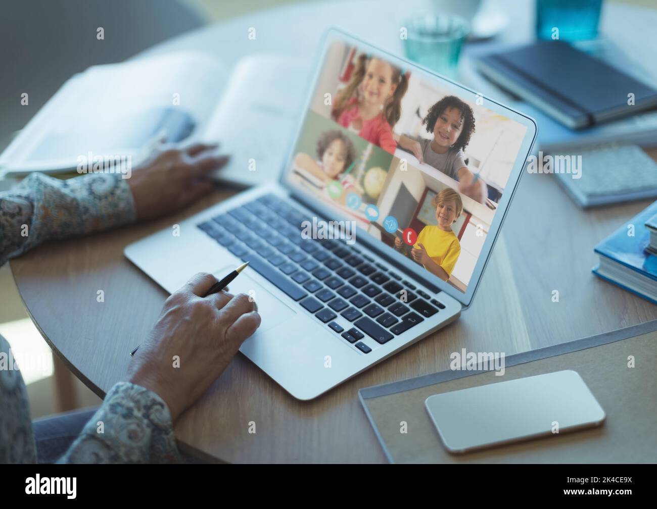 Mid section of female teacher having a video conference with multiple ...