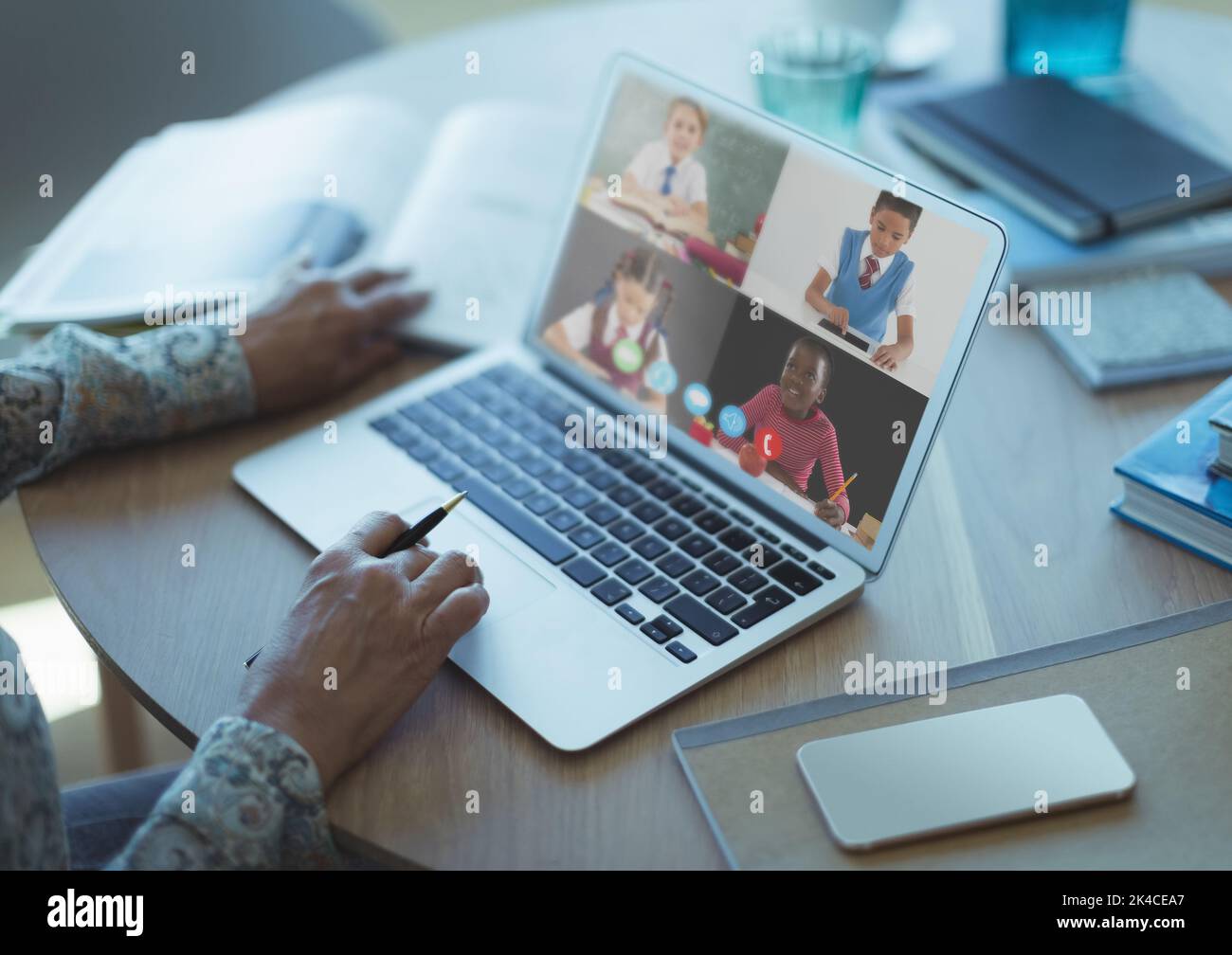 Mid section of female teacher having a video conference with multiple ...