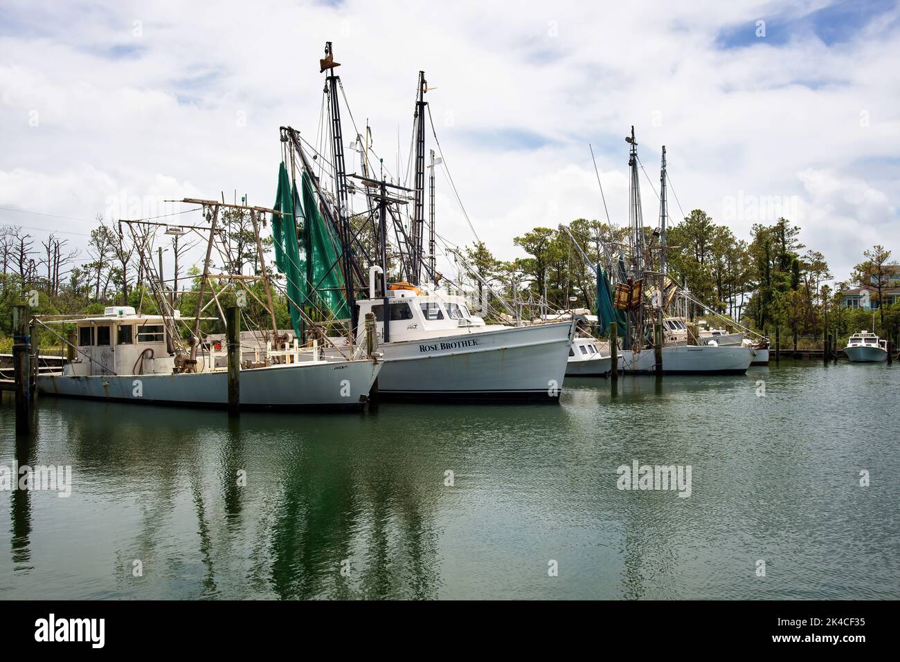 A set of white boats harbored at a dock on Harkers Island Stock Photo ...
