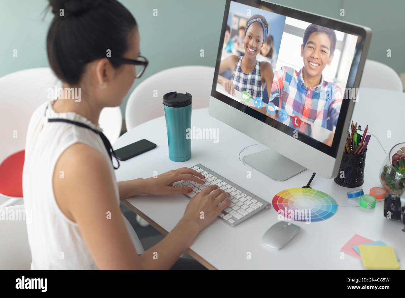 Female caucasian teacher having a video conference with male and female ...