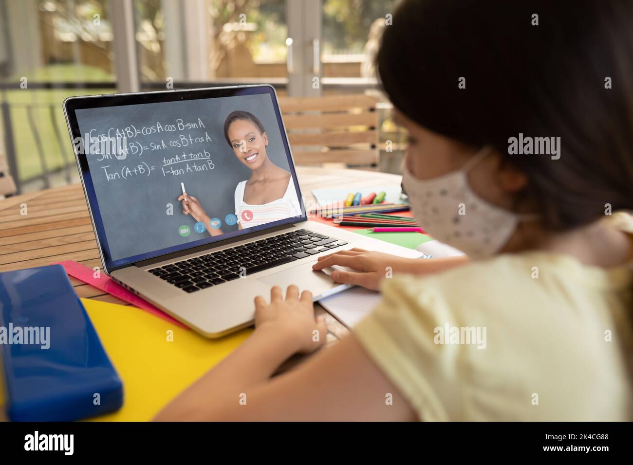 Female student wearing face mask having a video call with female ...