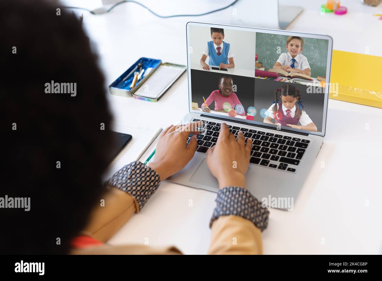 Female teacher having a video conference with multiple students on ...