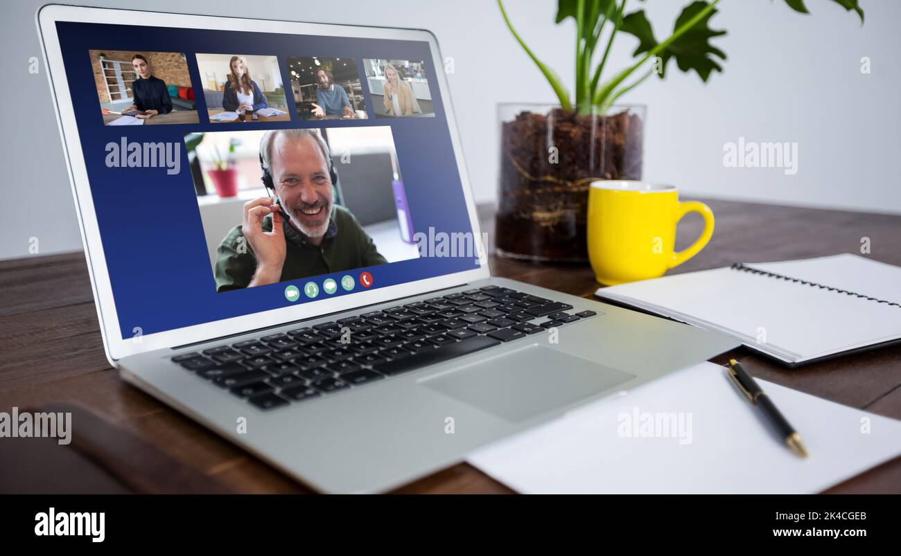 Laptop computer with a video call from businesspeople lying on desk ...