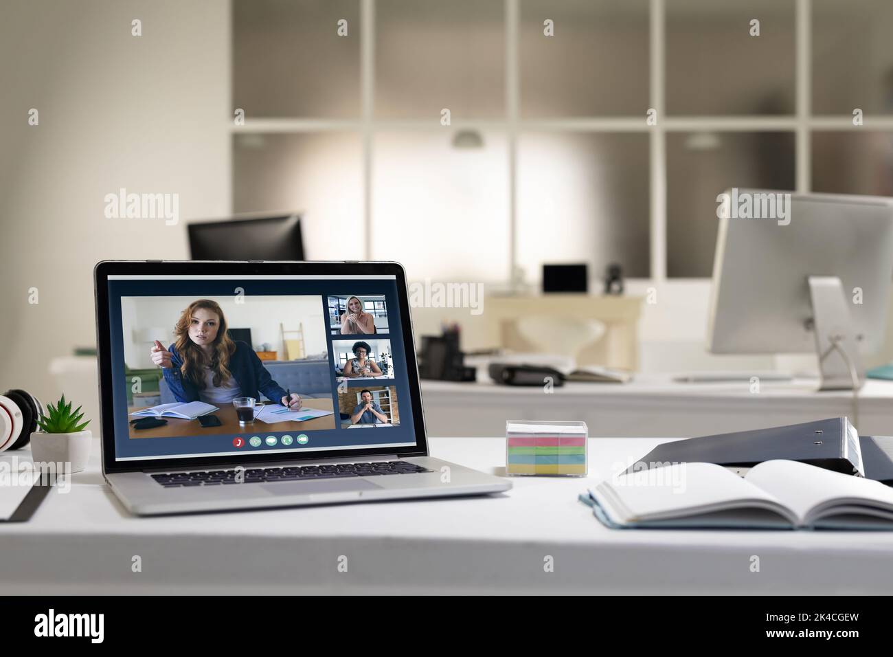 Laptop computer with a video call from businesspeople lying on desk ...