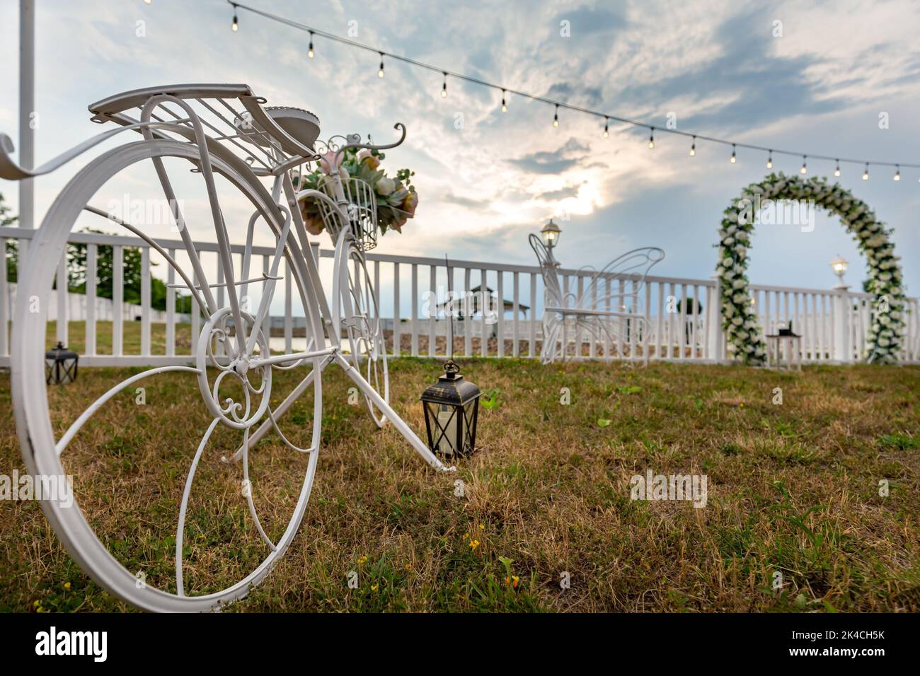 The view of a white decorative bicycle and flowers arch before the ...