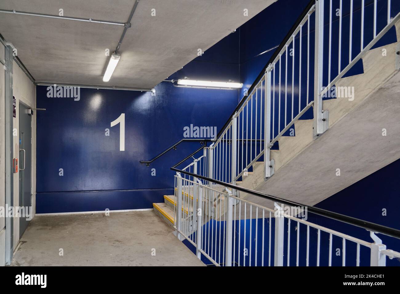 A number 1 on a blue-walled hallway and staircase Stock Photo - Alamy