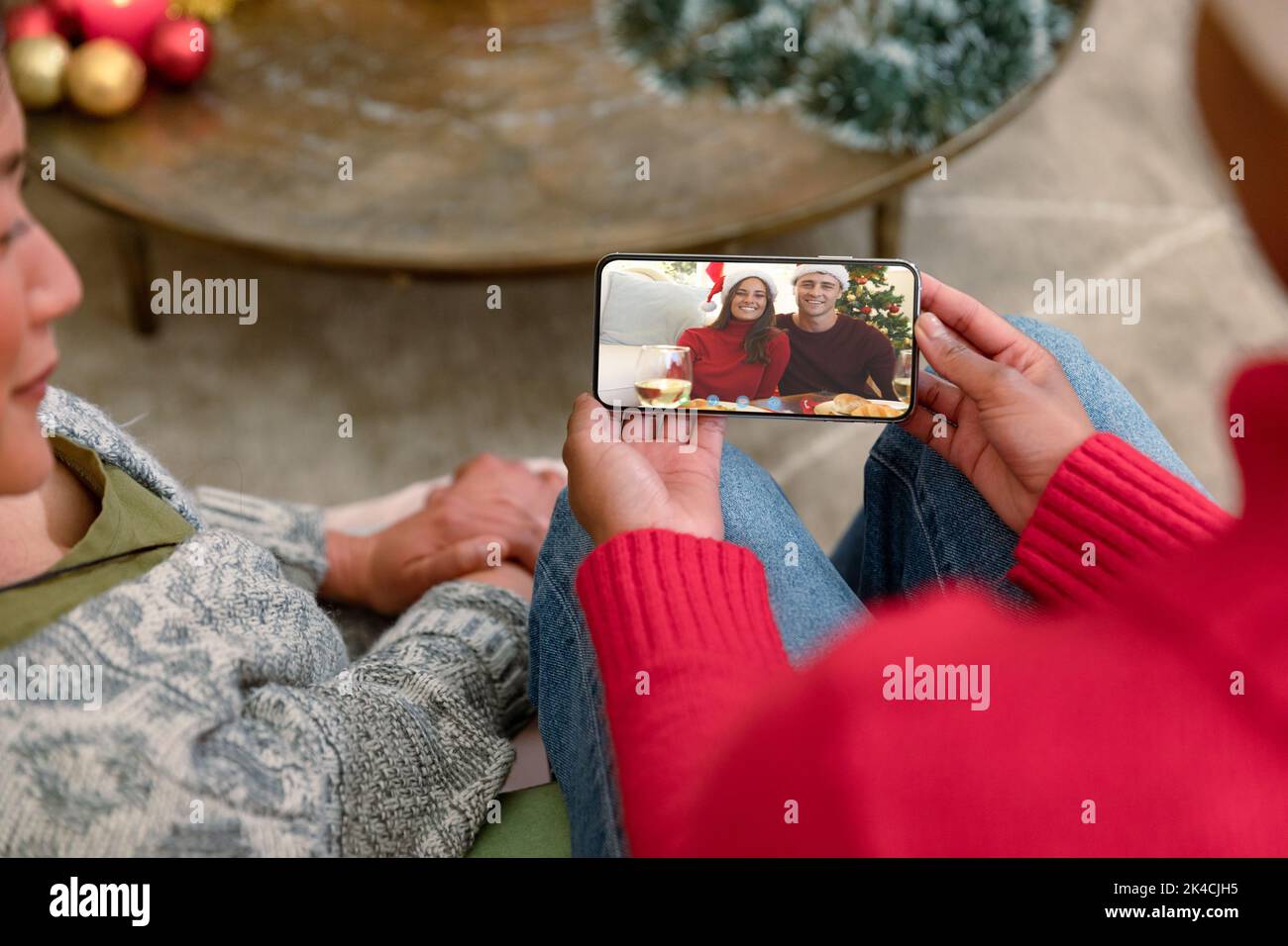 Two diverse female friends on christmas video call on smartphone with ...