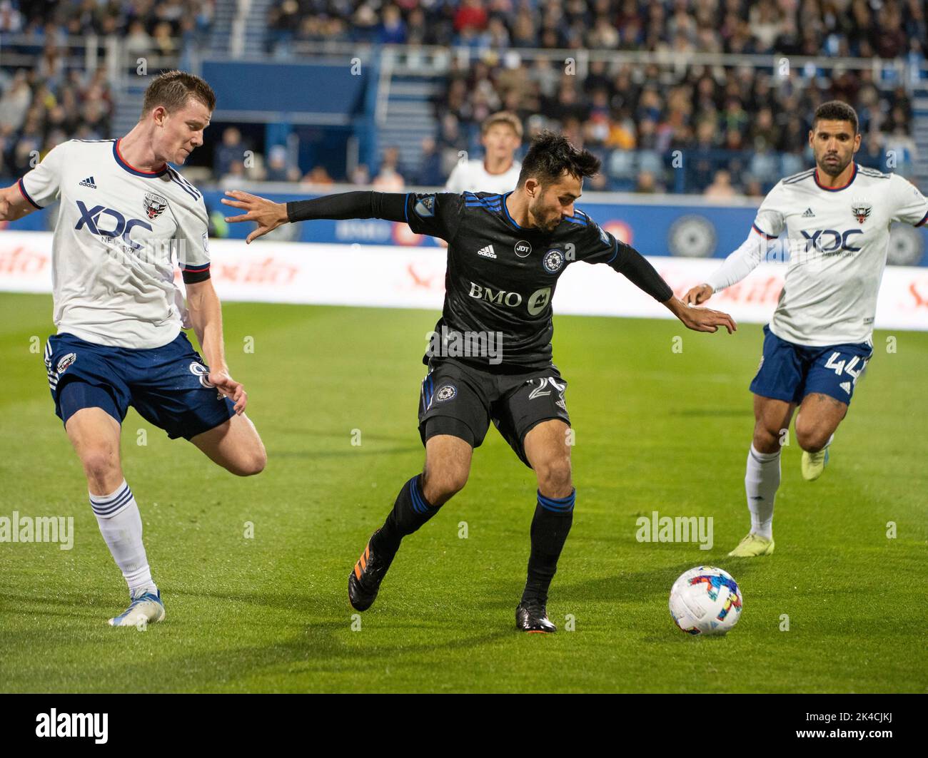 CF Montreal's Mathieu Choiniere, centre, protects the ball from D.C ...