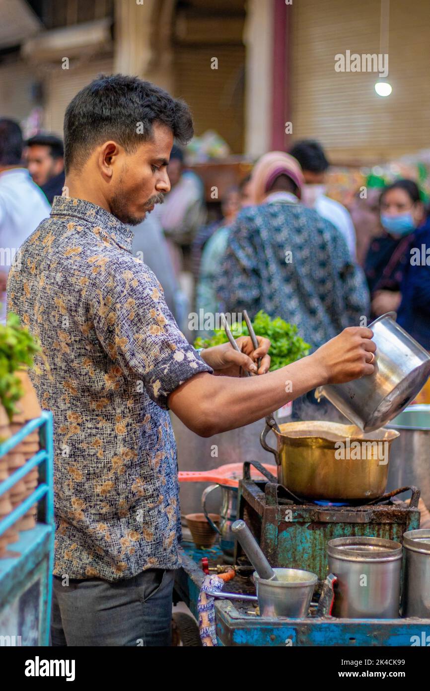 An Indian man cooking food in the street of the city market, vertical ...