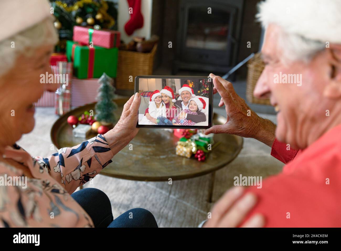 Happy caucasian senior couple making tablet christmas video call with ...