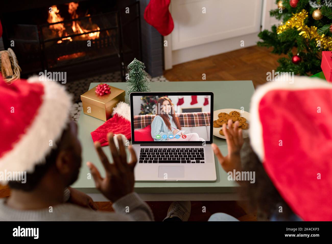 Waving african american couple making laptop christmas video call with ...