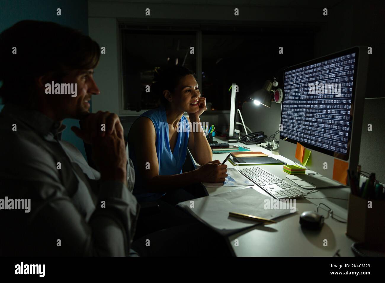 Smiling diverse male and female colleague at desk using computer with ...